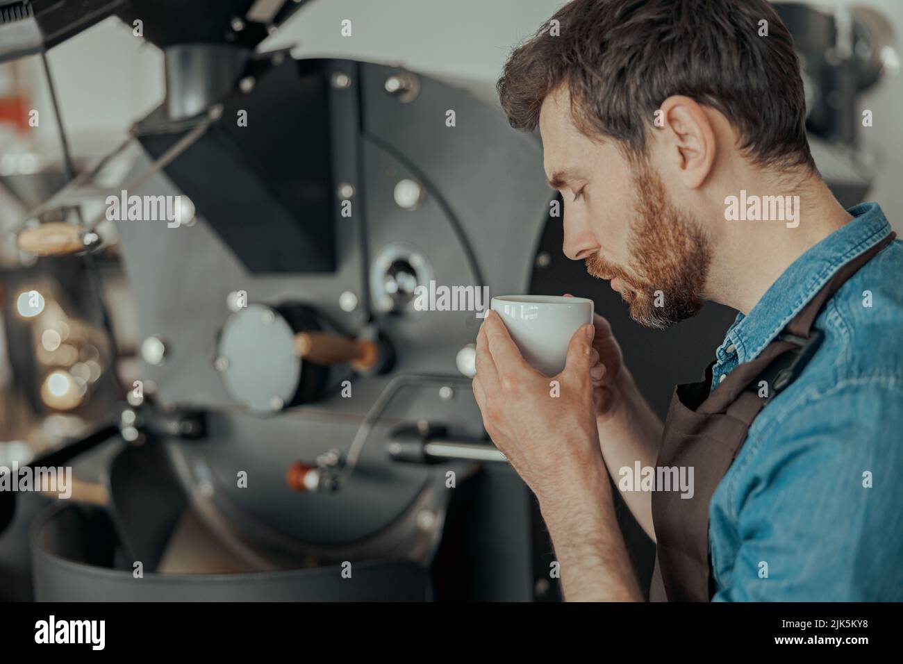 Male barista inhaling aroma of fresh made coffee on the background of ...