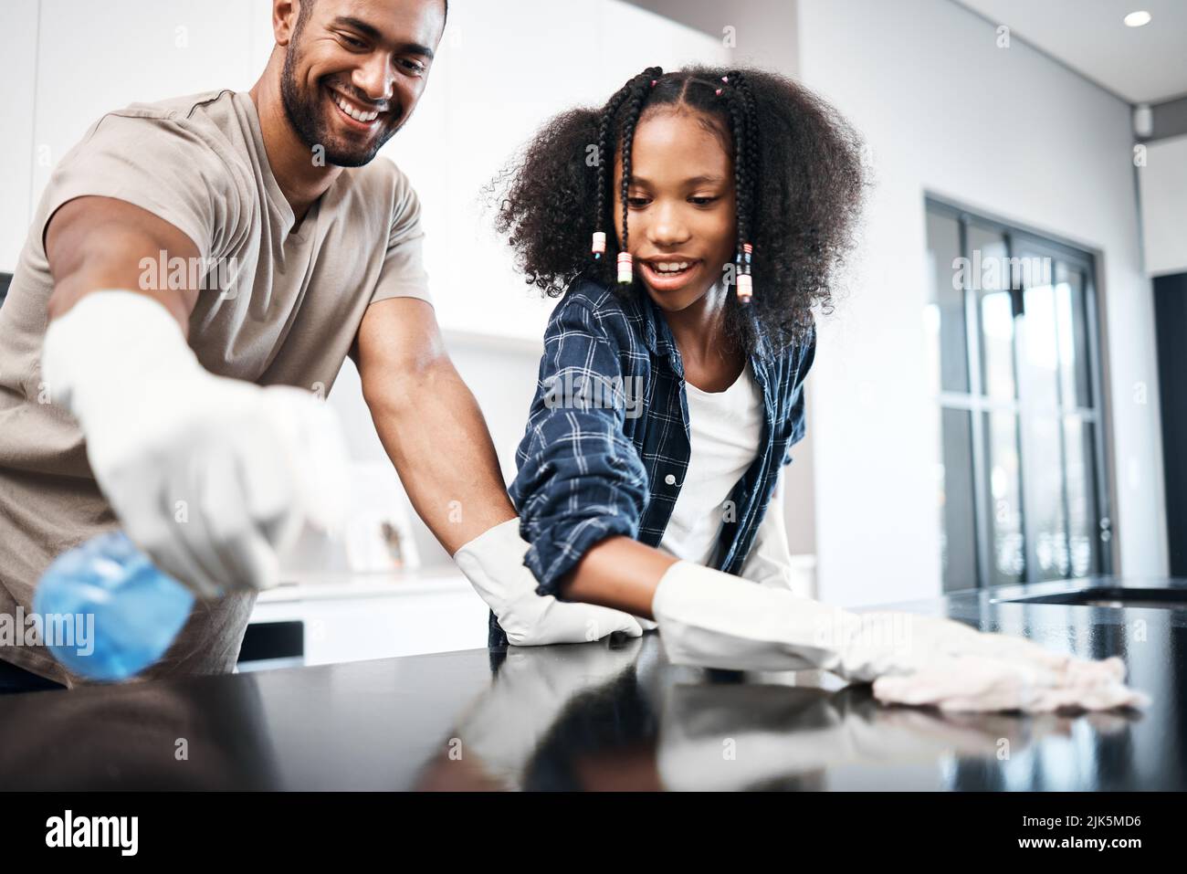 We mean clean. a young girl helping her father clean the kitchen ...