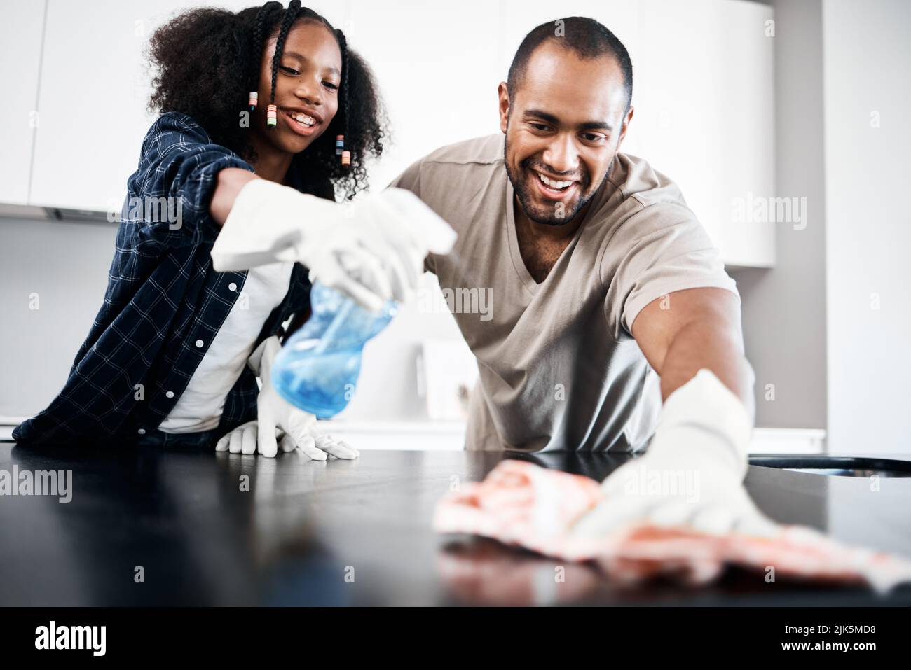 No mess is too much for us. a young girl helping her father clean the ...