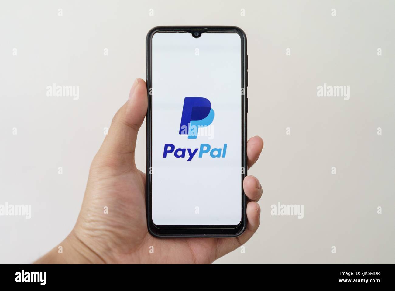 A hand holds smartphone shows PayPal logo Stock Photo - Alamy