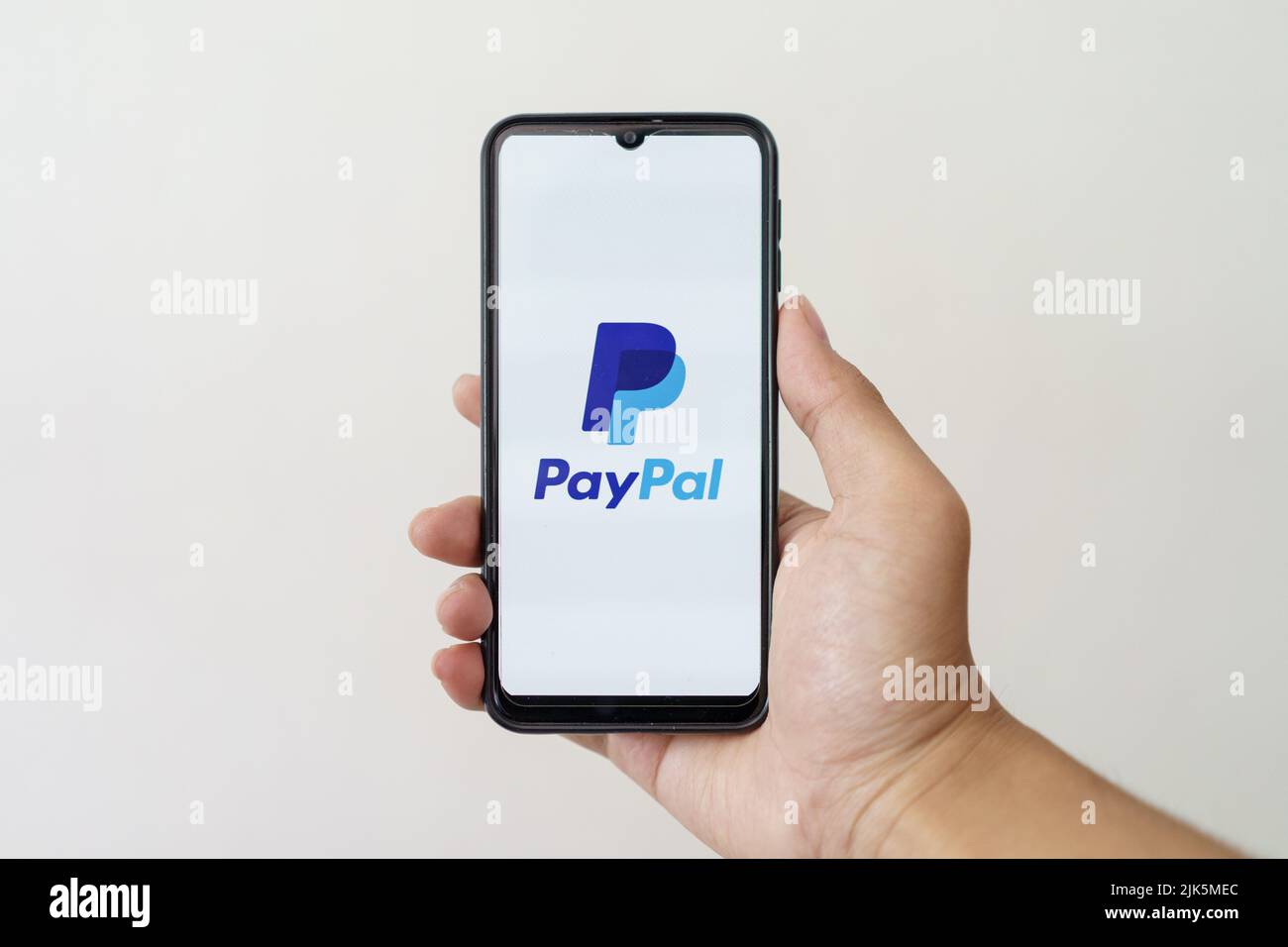A hand holds smartphone shows PayPal logo Stock Photo - Alamy