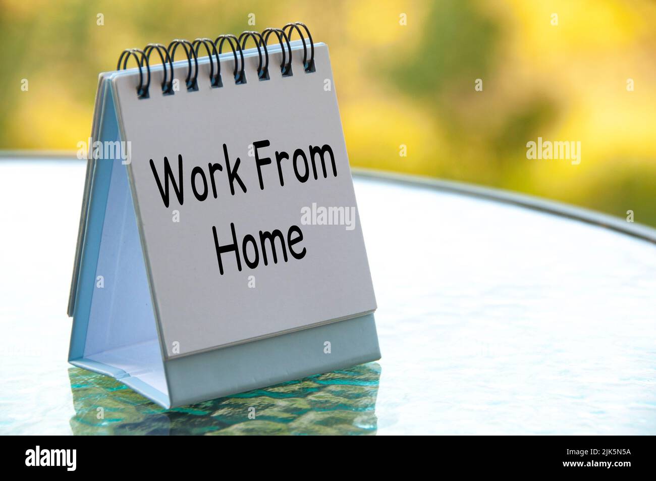 Work from home text on white calendar table with blurred nature ...
