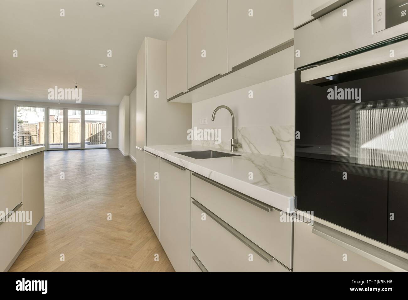 Interior of empty white kitchen with windows and wooden parquet floor ...