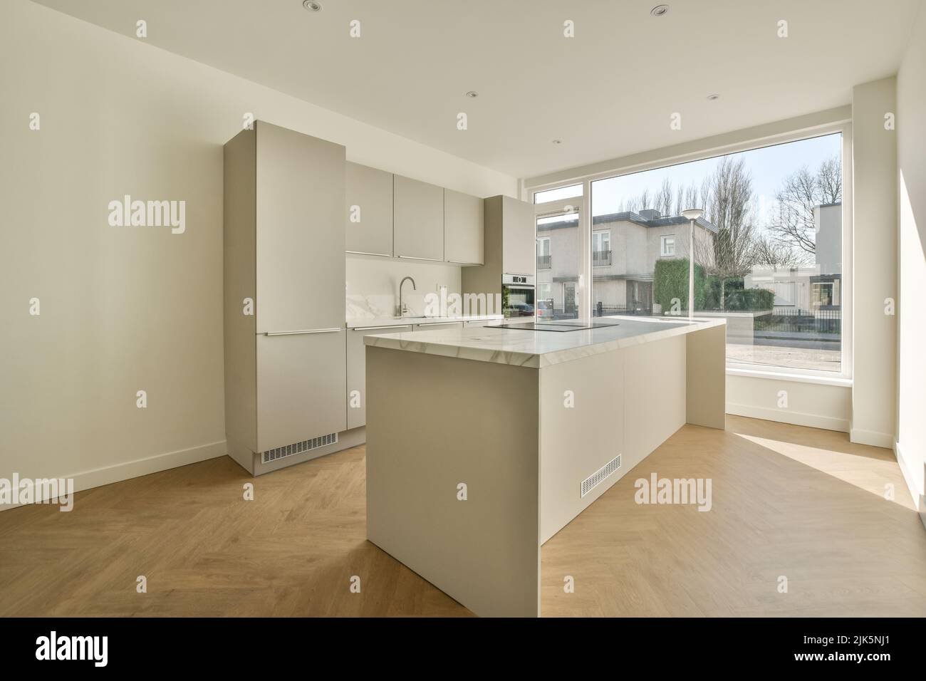 Interior of empty white kitchen with windows and wooden parquet floor ...