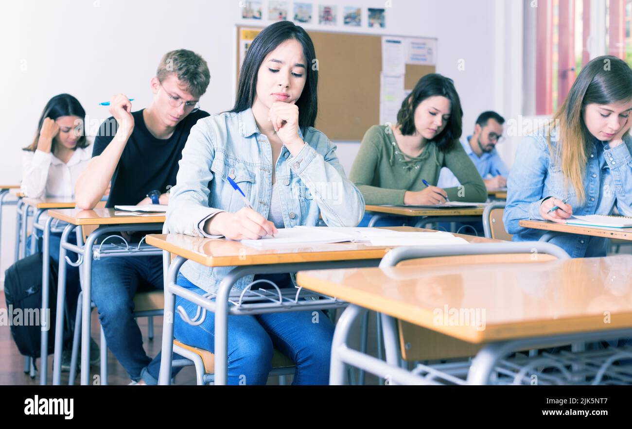 Girl writing test in classroom Stock Photo - Alamy
