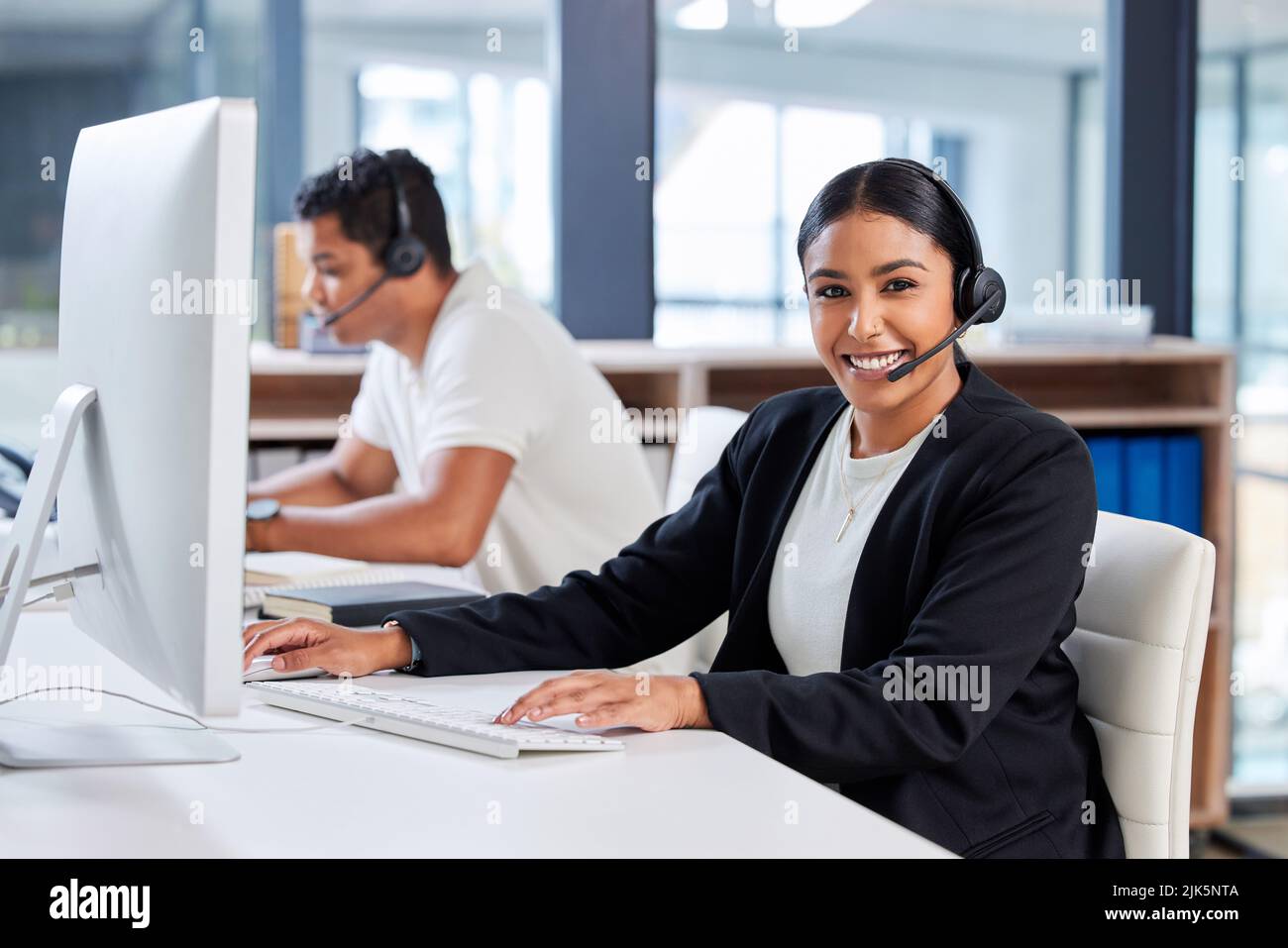 Leave the resolving of issues to us. two young businesspeople sitting ...