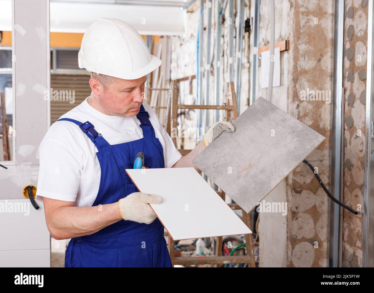 Worker picking ceramic tiles Stock Photo - Alamy