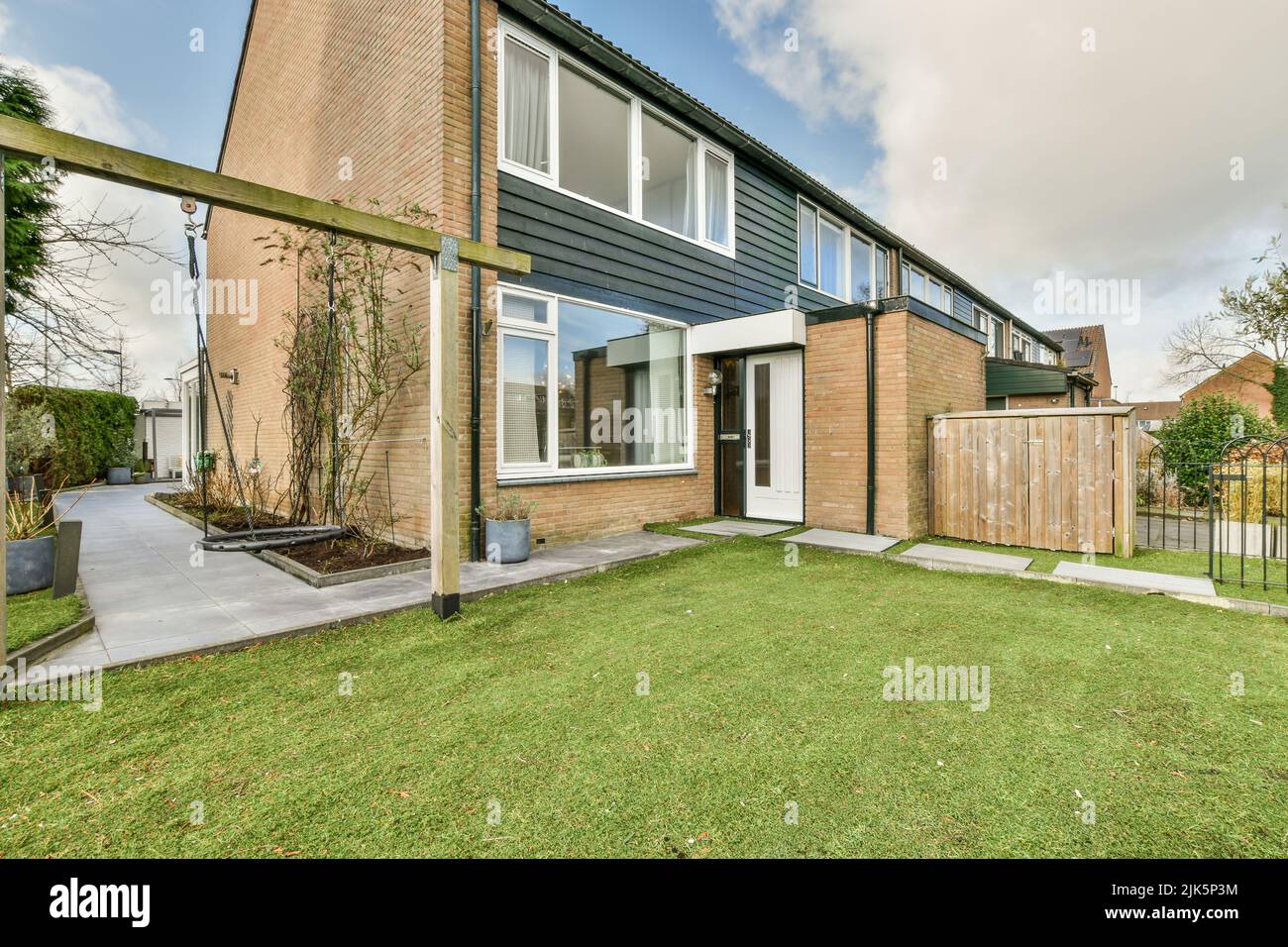 The front view of a brick building with signs, pavement and wooden ...