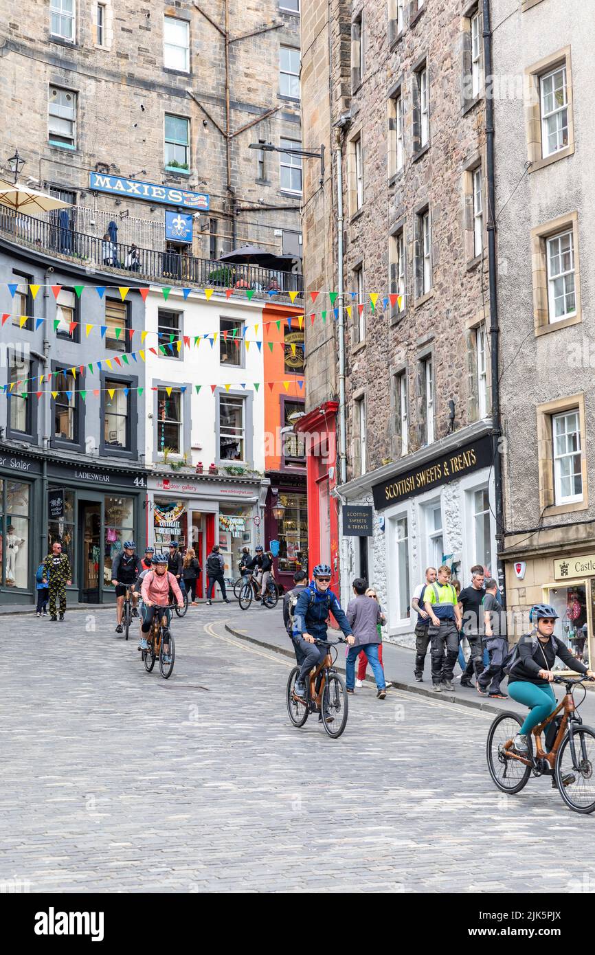 Bike tour around Edinburgh, people riders with helmets on cycles in ...