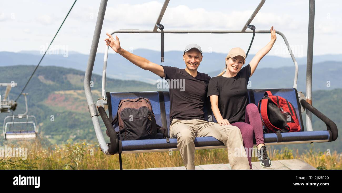 Man and a woman riding on the lift down the scenic Mountain during ...