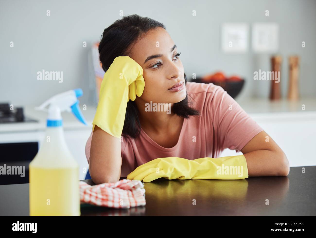 I wonder if ill ever finish cleaning. a young woman taking a break form ...