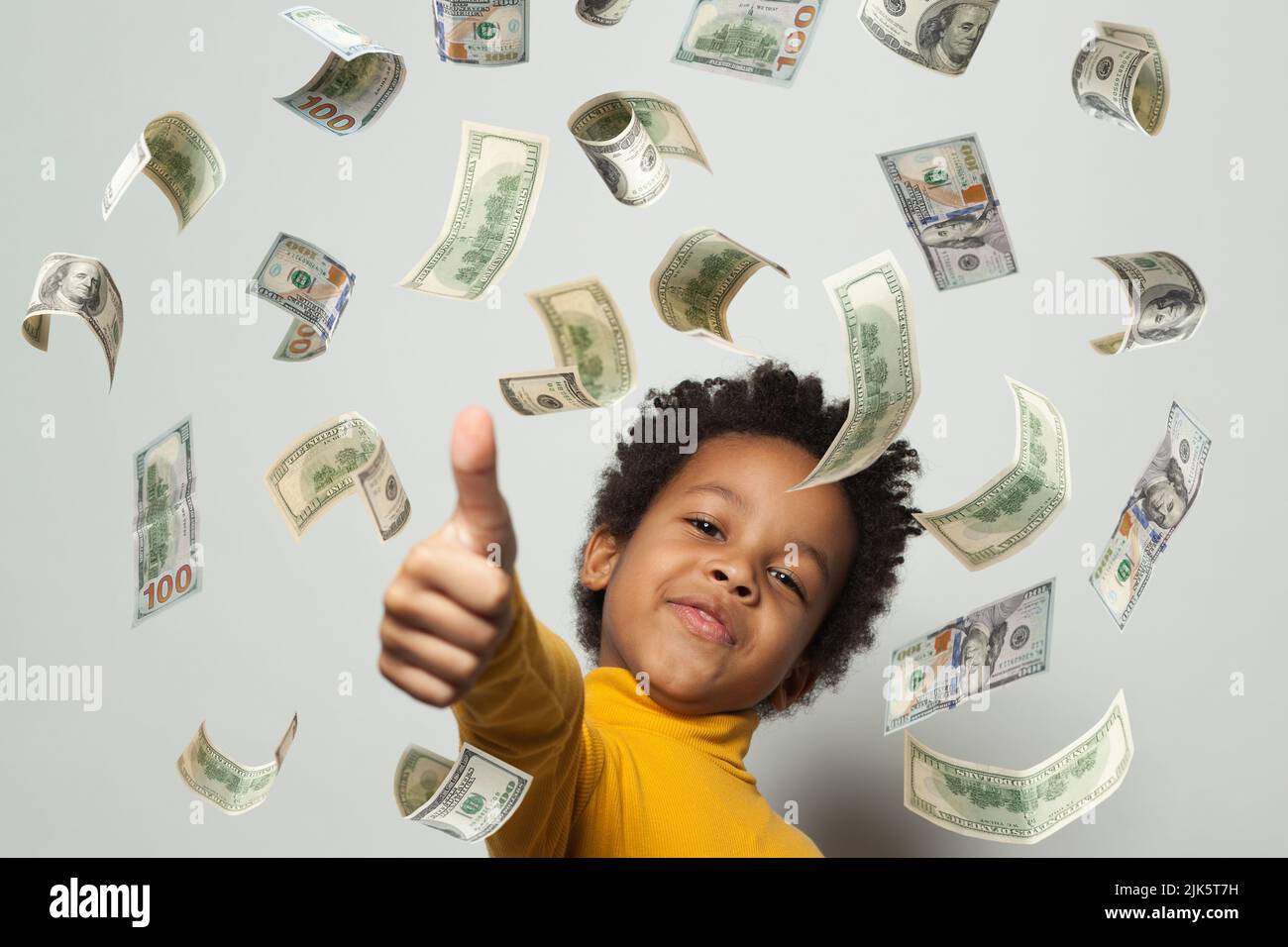 Adorable kid young boy in the rain of money on white background Stock ...