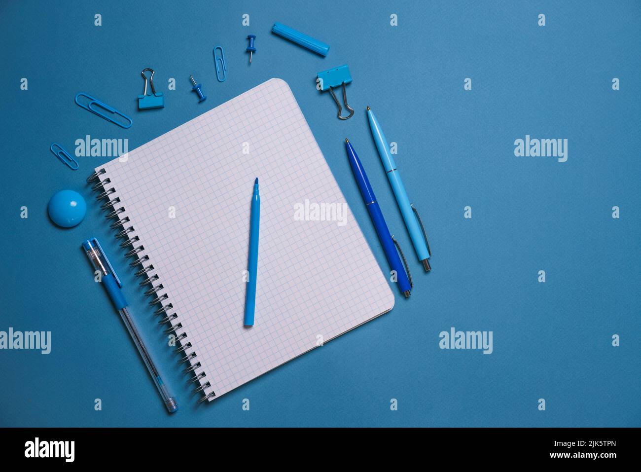 Stationery. Open notebook pencils and pens, stickers and binding clips ...