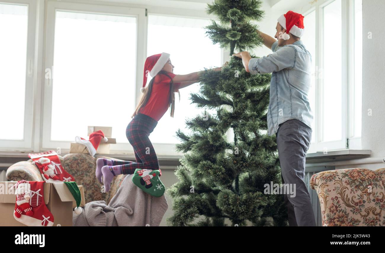 father and daughter install an artificial Christmas tree Stock Photo ...