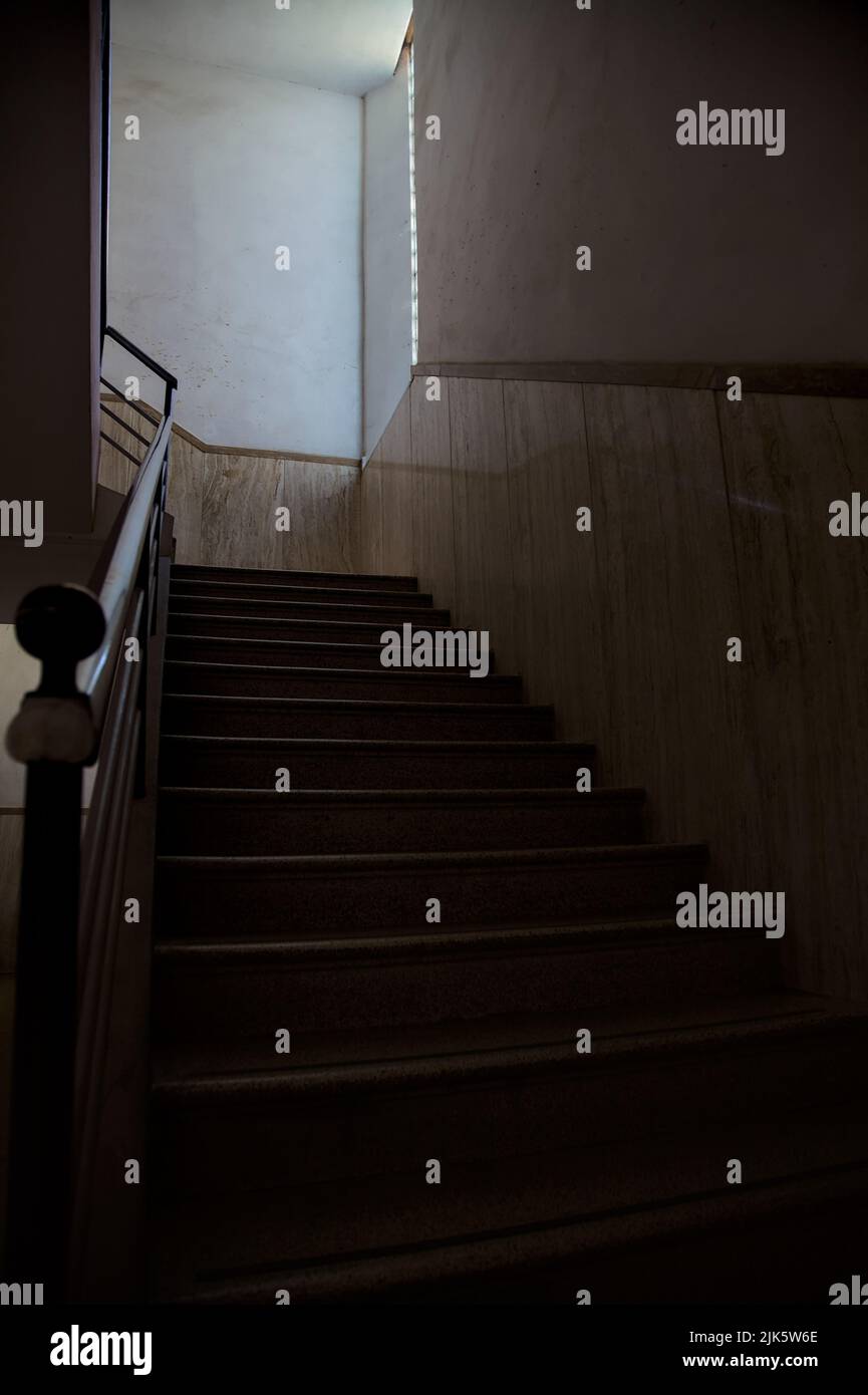 Staircase lit by a feeble light coming from a window Stock Photo - Alamy