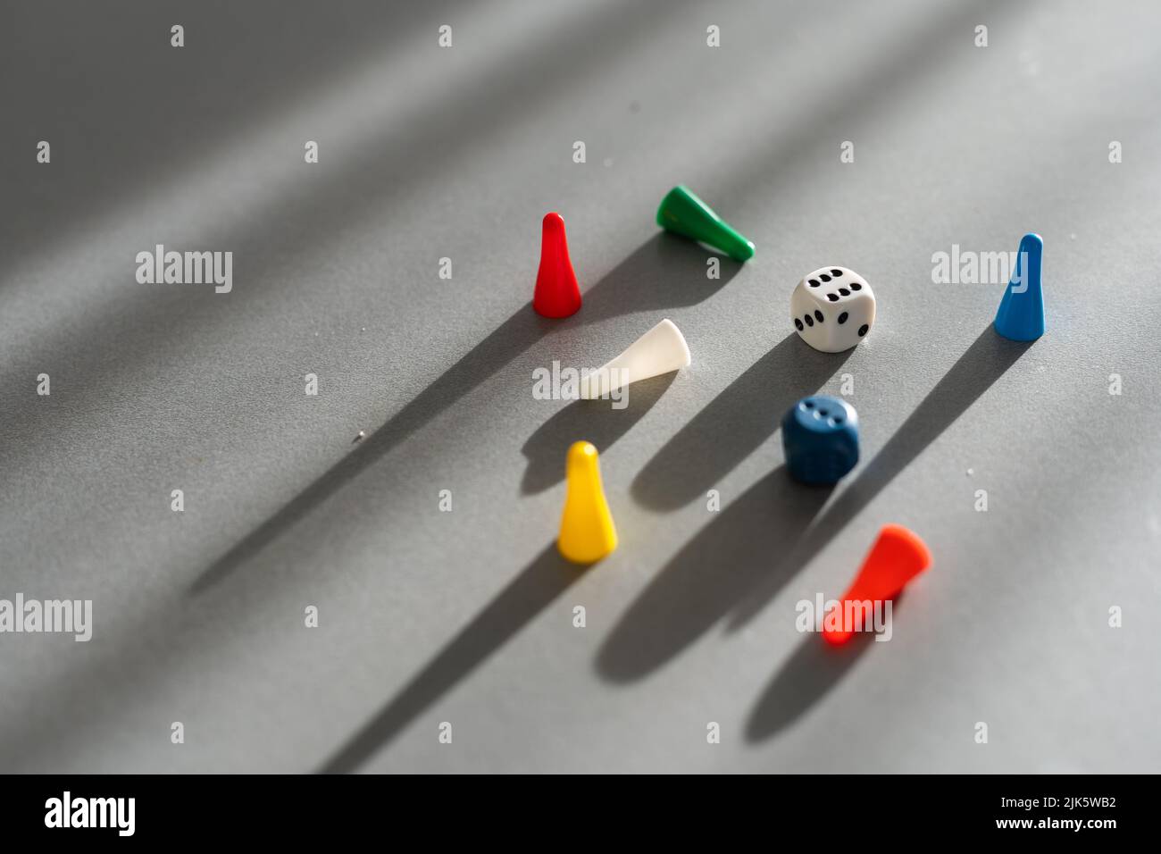 Colored game chips and playing cubes laid out on a gray background ...