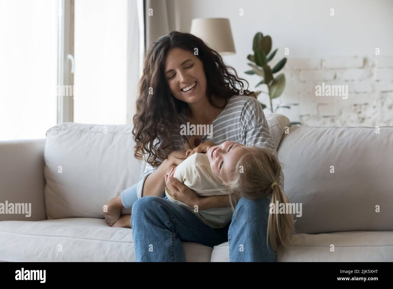 Young mother tickling daughter play hi-res stock photography and images ...
