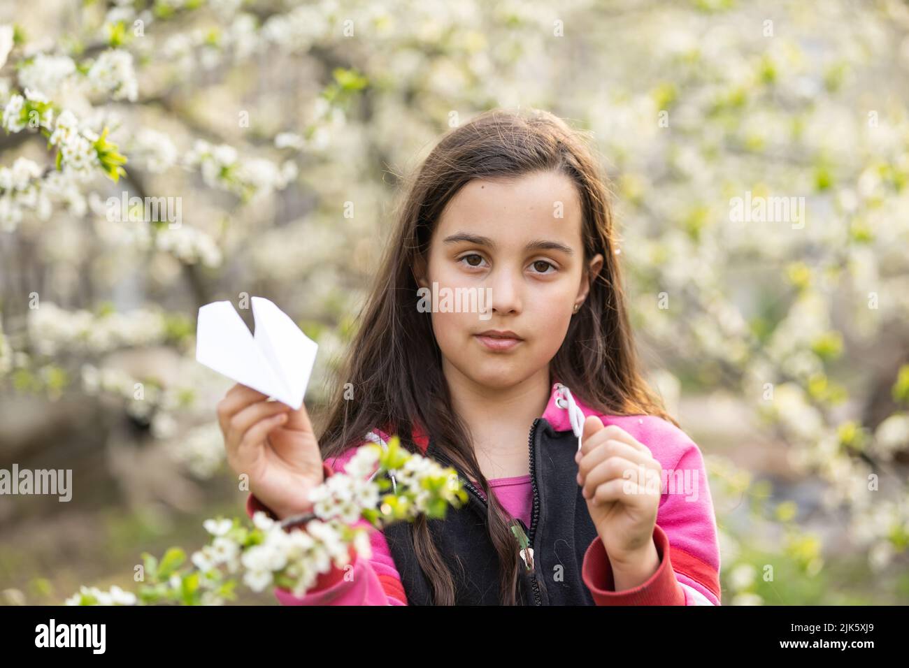 Above closeup view image of little girl playing with a paper plane in ...