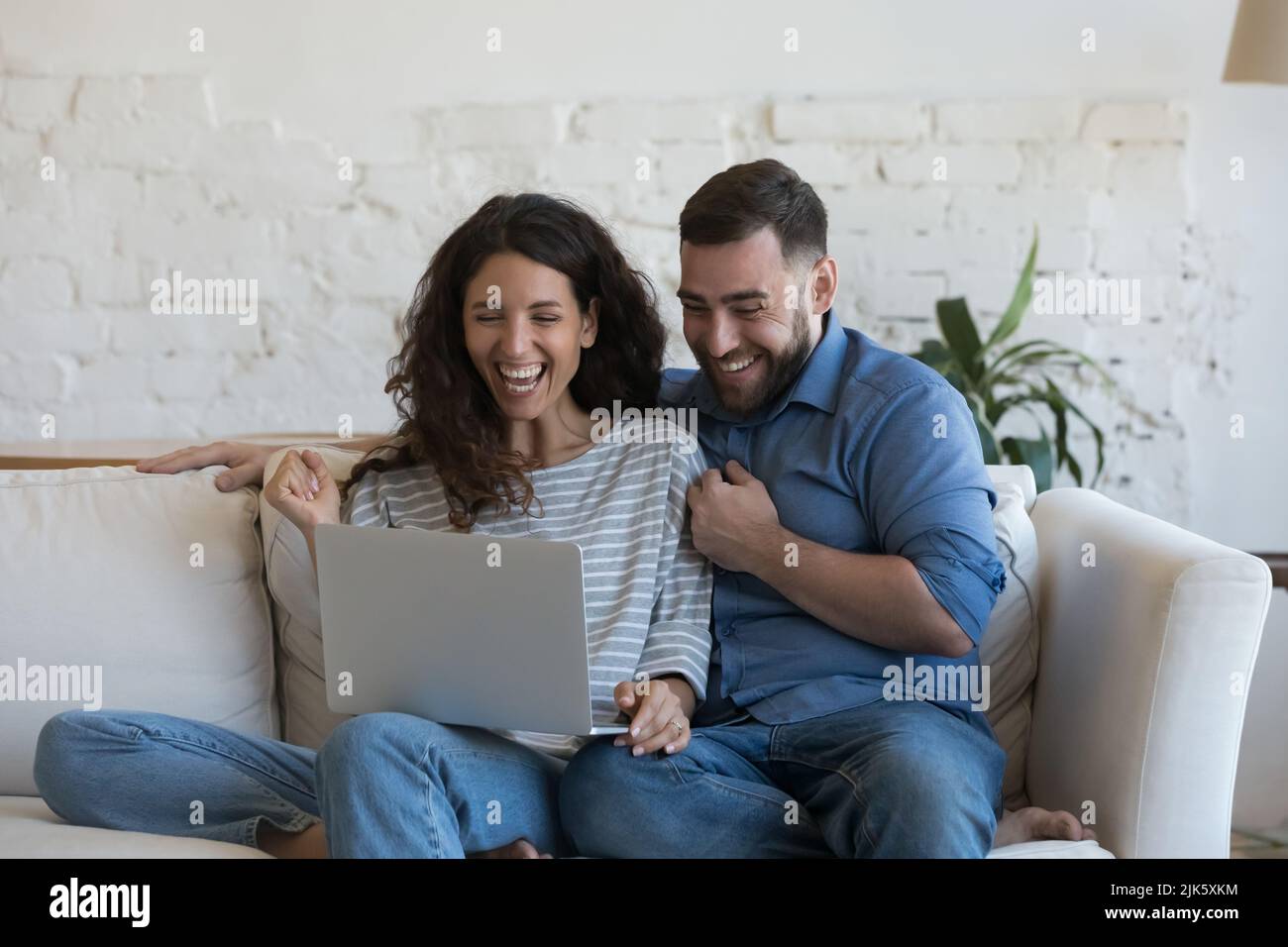 Excited Millennial Married Couple Looking At Laptop Computer Screen