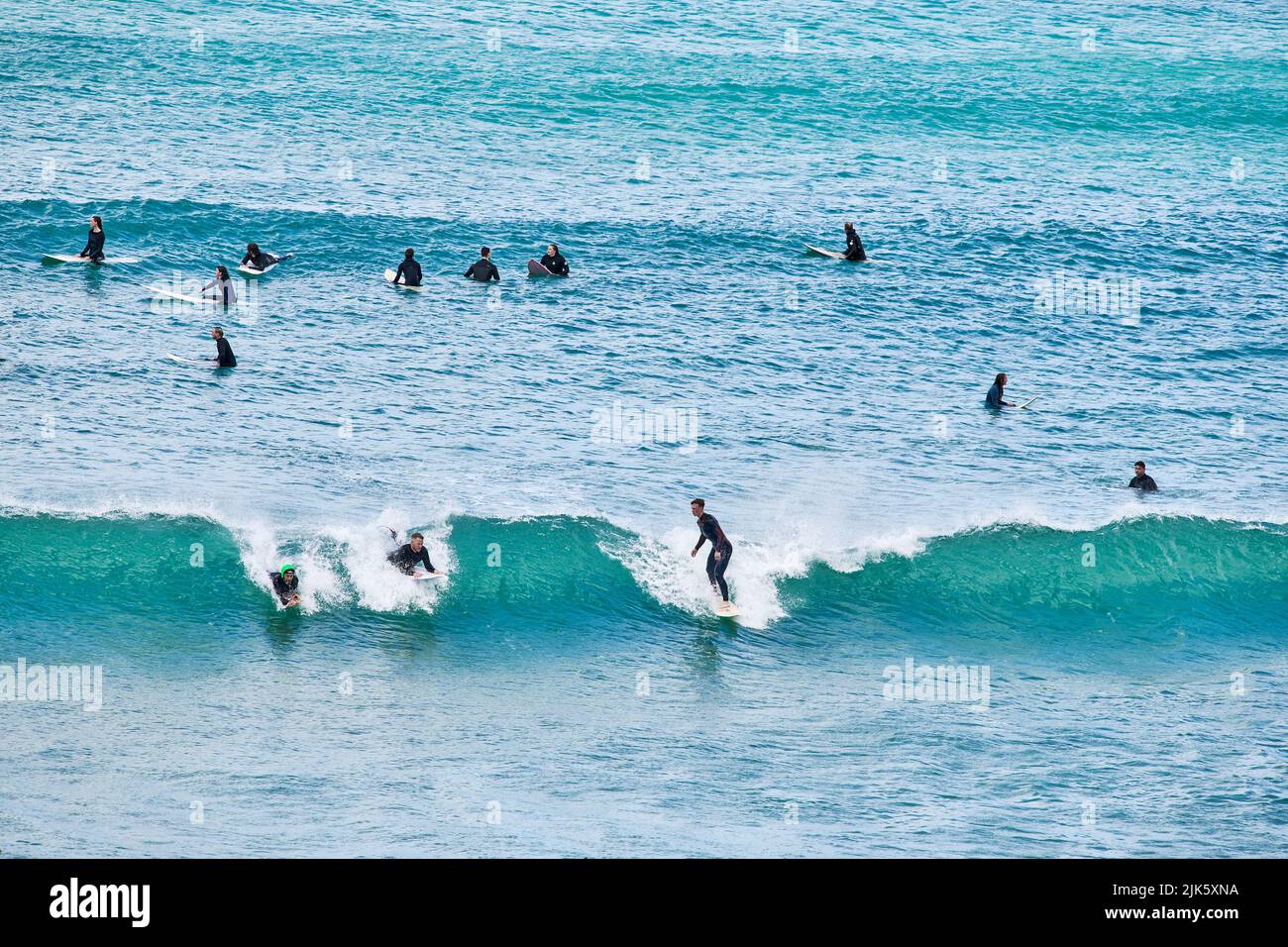 Surfers on a surf wave at the Towan beach, Newquay, Cornwall, England ...