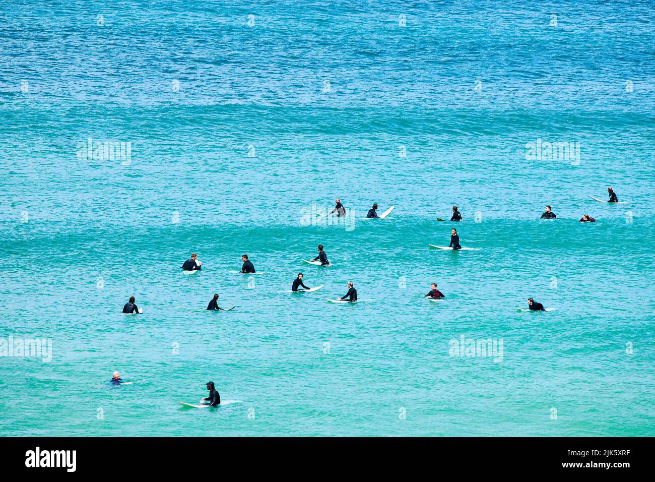Surfers wait for a surf wave at the Towan beach, Newquay, Cornwall ...