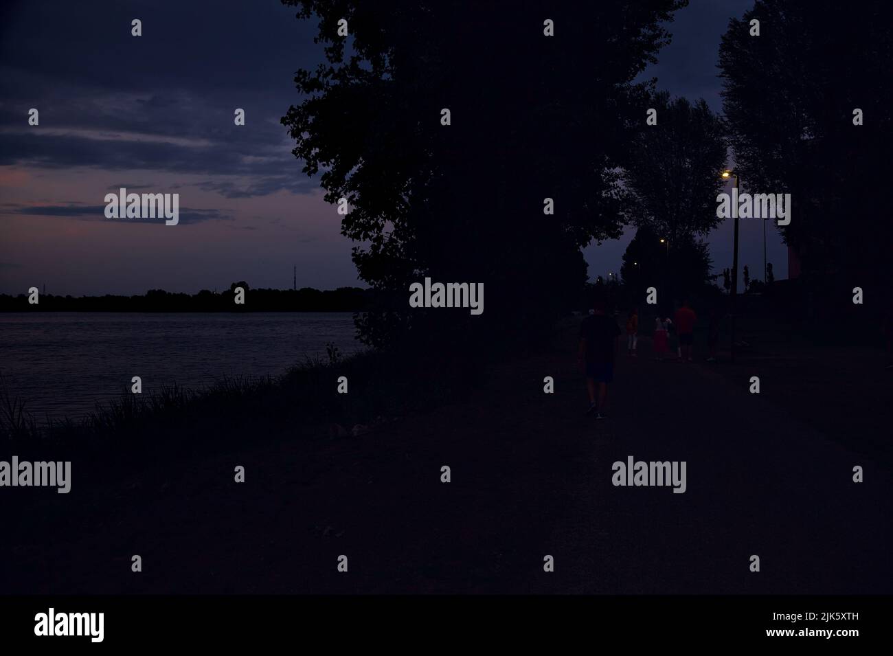 Path in a park by the lakeshore at twilight Stock Photo - Alamy