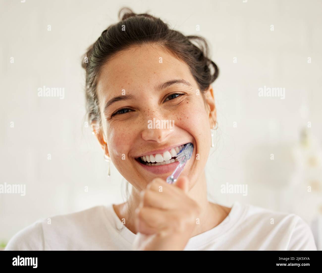 A beautiful smile is easy to achieve. a young woman brushing her teeth ...