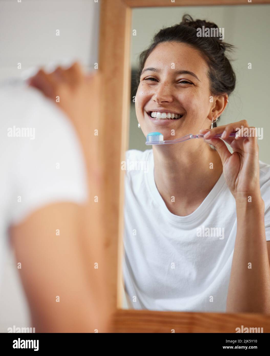Starting The Day Bright A Young Woman Brushing Her Teeth While Looking