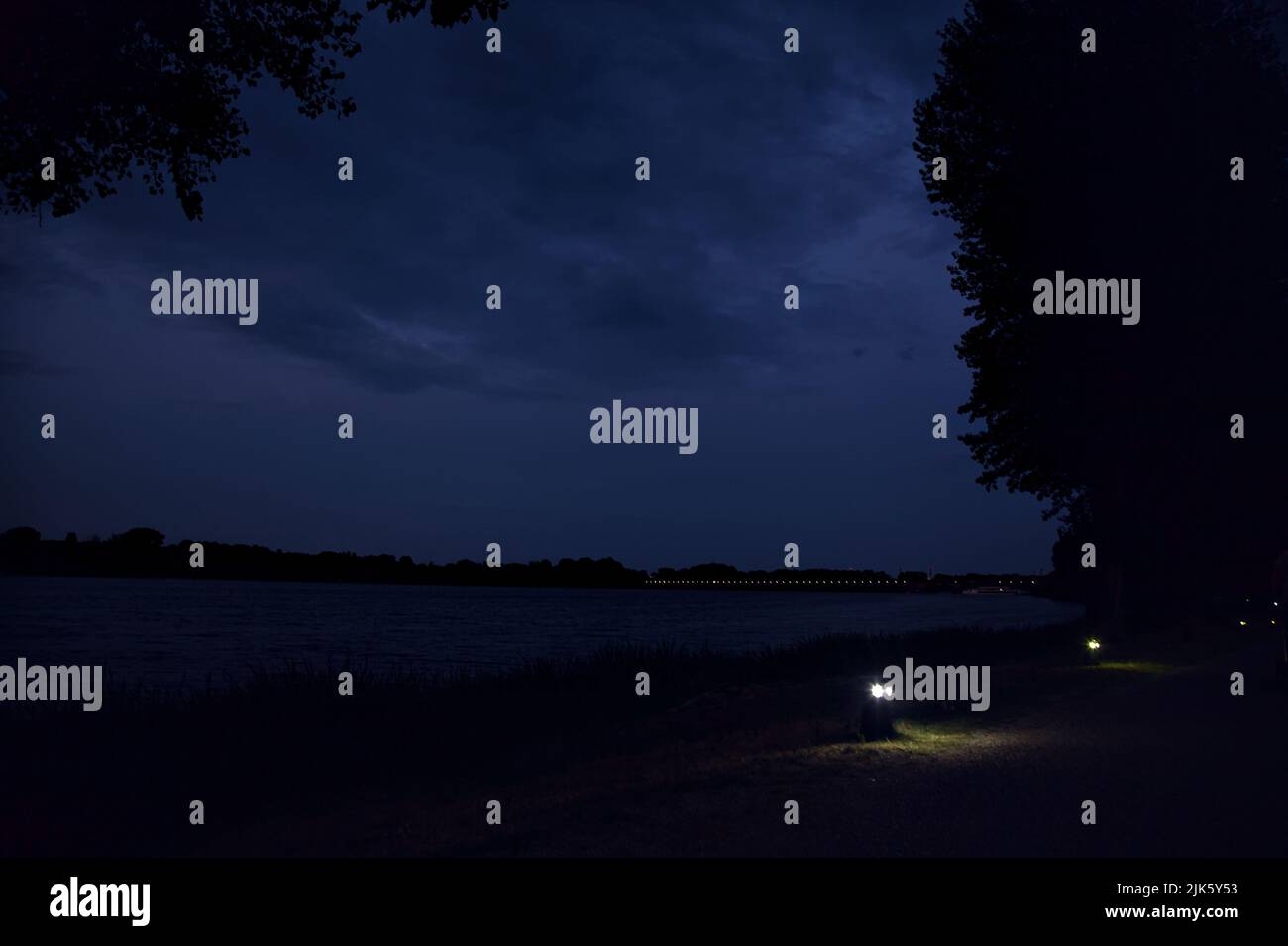 Path in a park by the lakeshore at twilight Stock Photo - Alamy