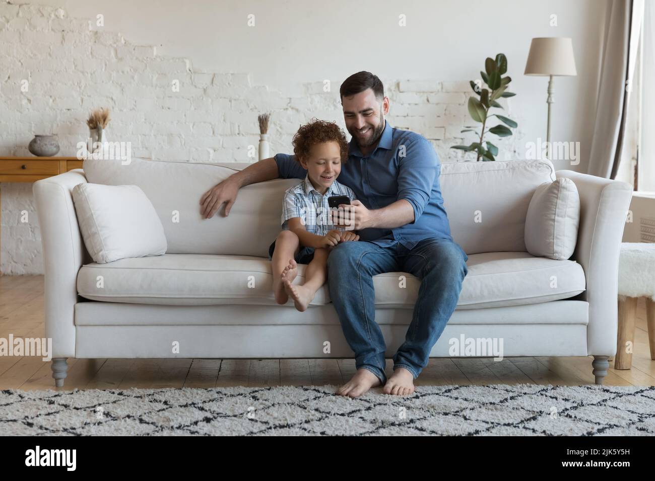 Happy dad hugging cheerful little son kid with love Stock Photo - Alamy