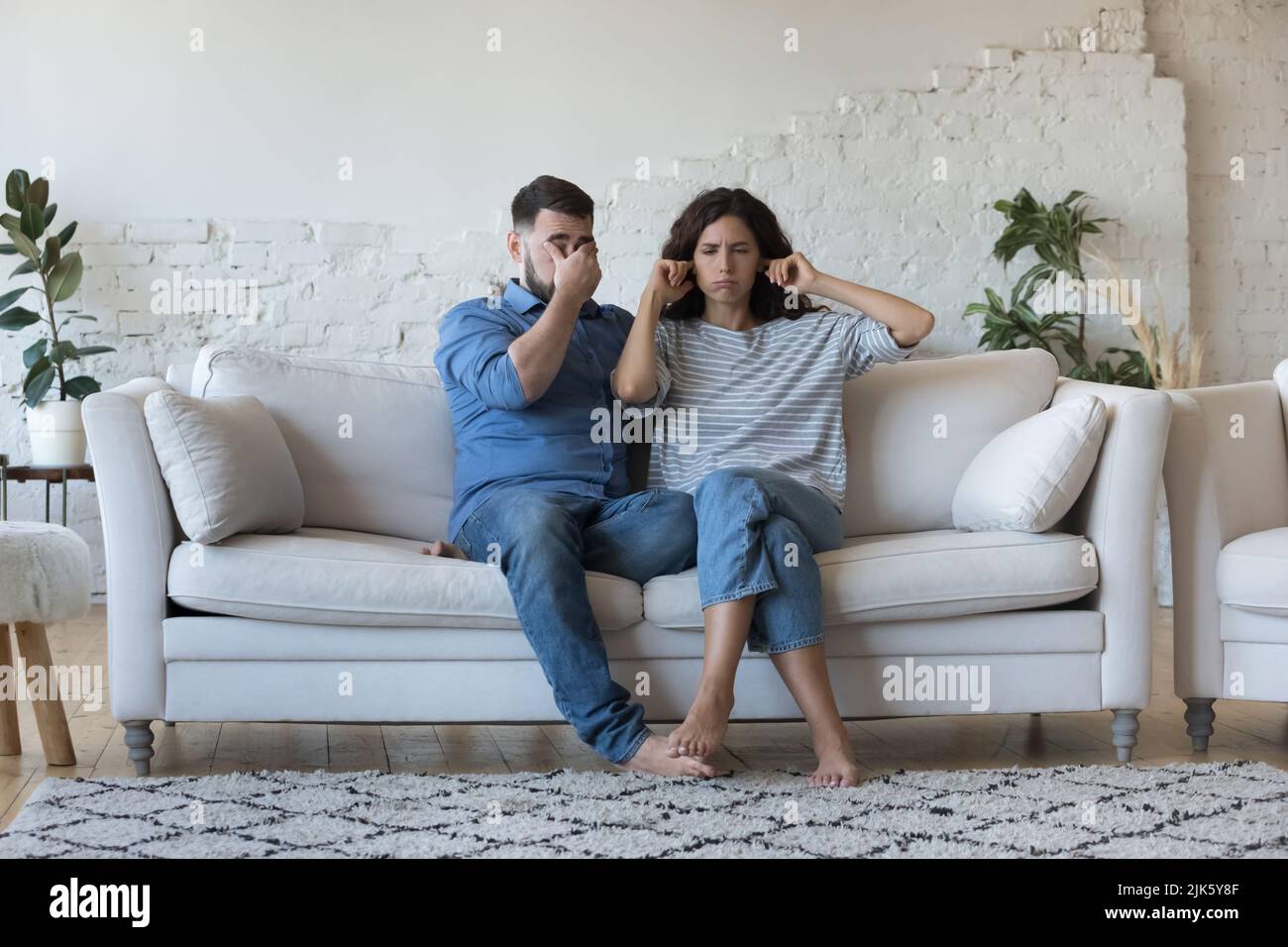 Tired stressed young couple arguing at home, sitting on sofa Stock ...