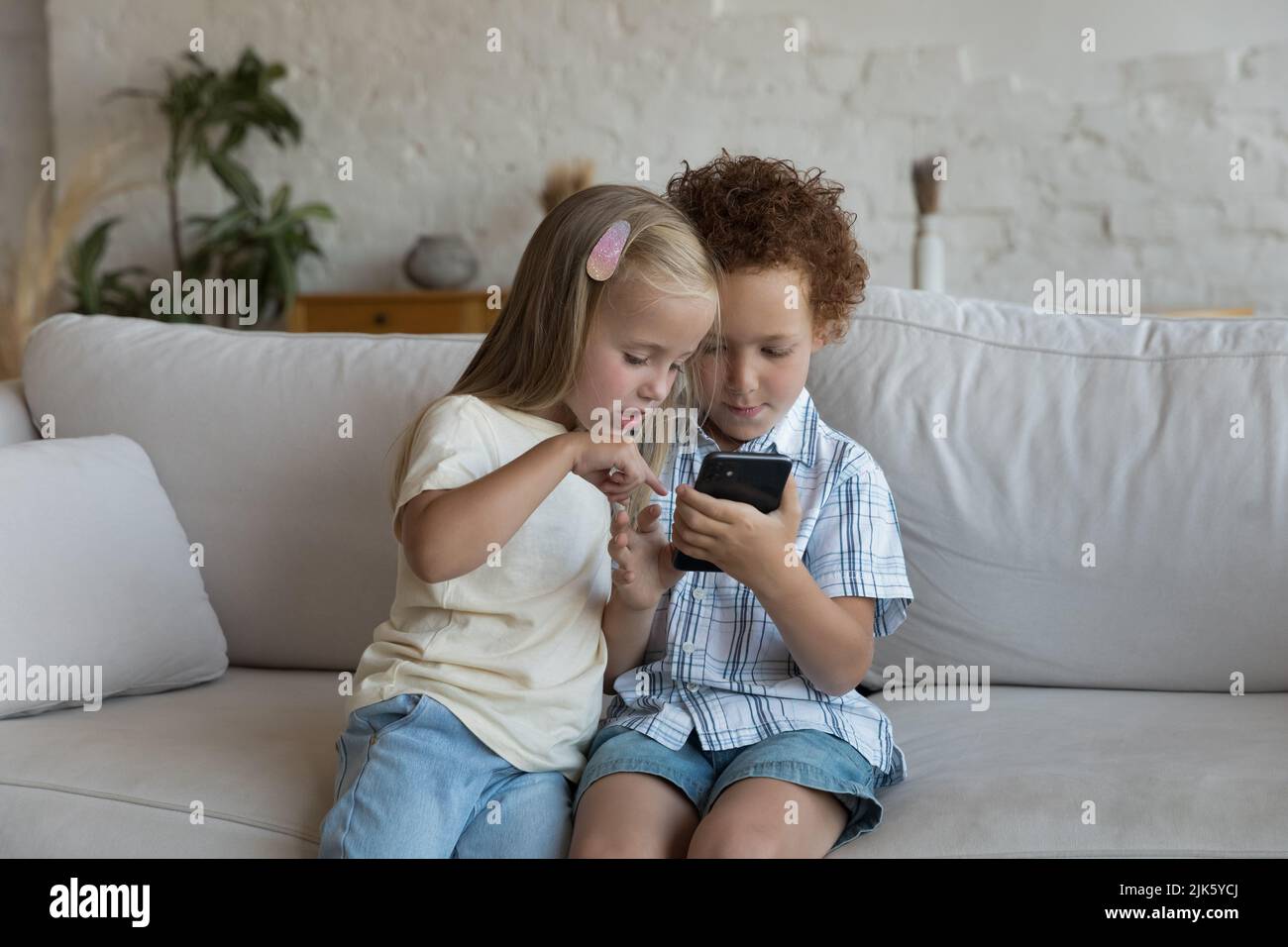 Two gen Z sibling children using app on mobile phone Stock Photo - Alamy