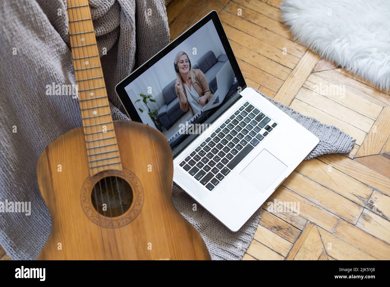 Young woman practicing and learning how to play guitar on laptop ...