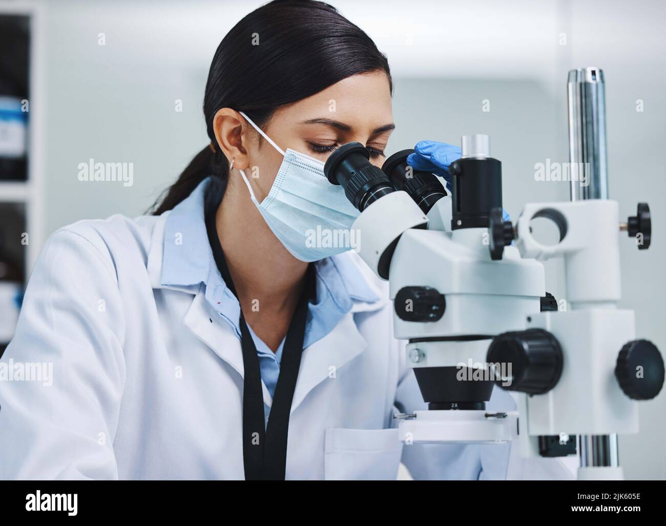 Lets see whats under this microscope. a young female researcher working ...