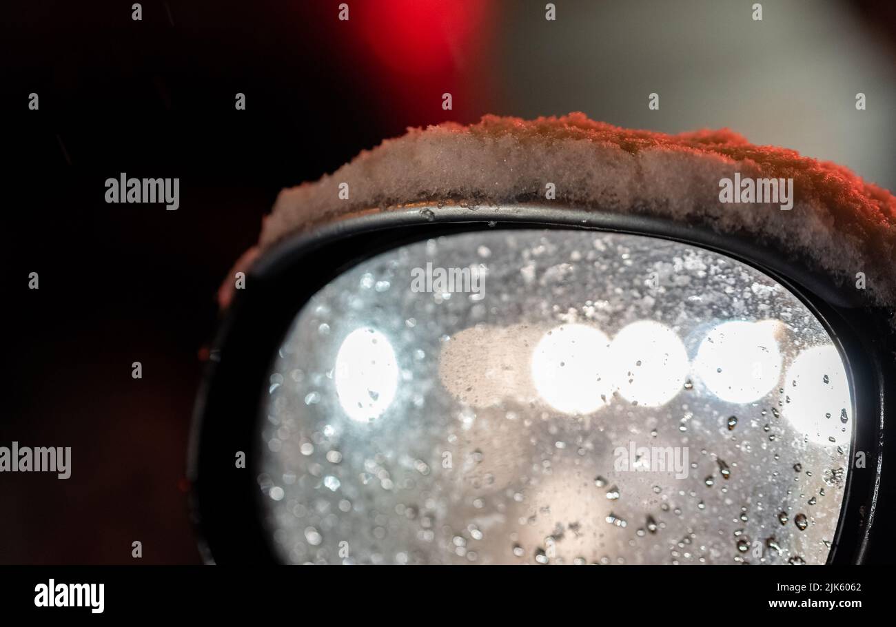 Car side mirror with snow. Reflection of lights in the car mirror at ...