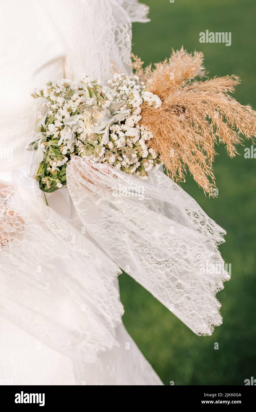 beautiful tender wedding bouquet of cream roses flowers in hands of the ...