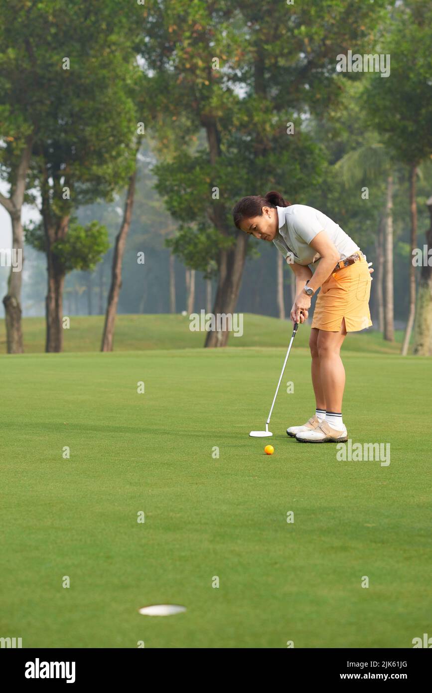 Asian female golf player concentrated on game Stock Photo - Alamy