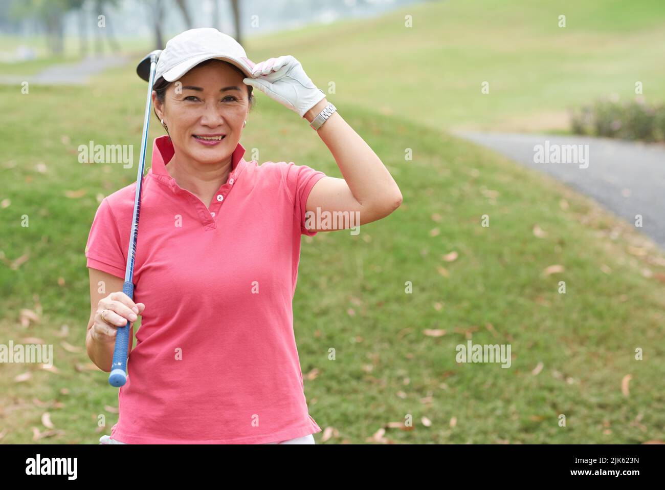 Portrait happy Asian female golfer with a club Stock Photo - Alamy