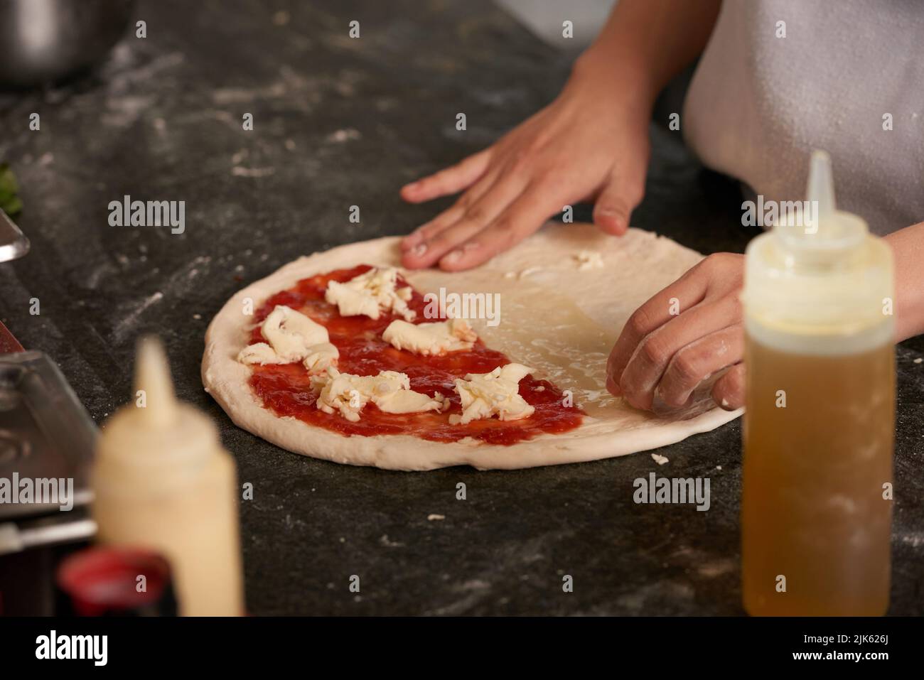 Hands of person putting toppings on the pizza Stock Photo - Alamy