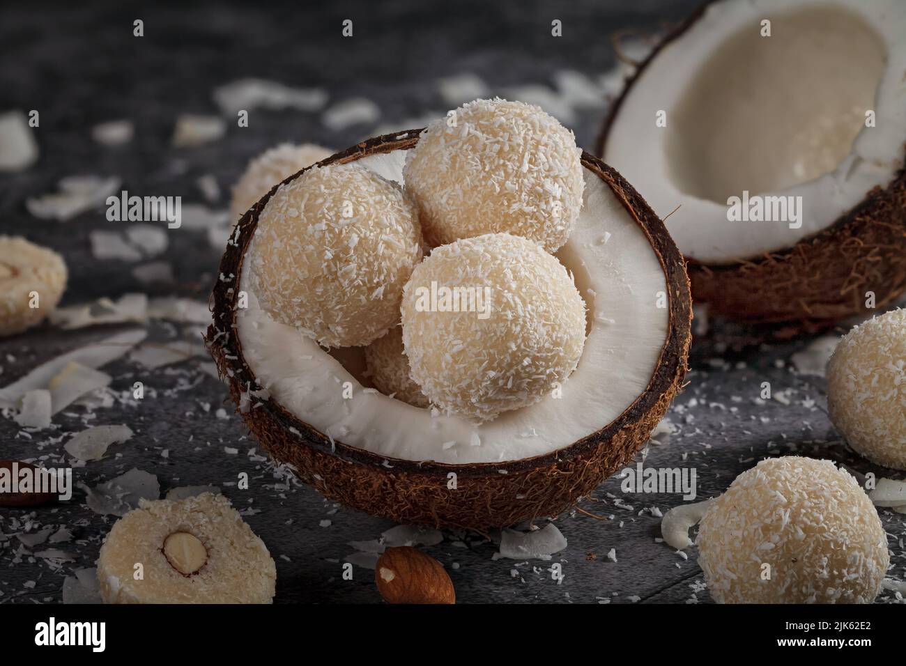 Homemade raffaello candies are inside half of the coconut on a gray ...