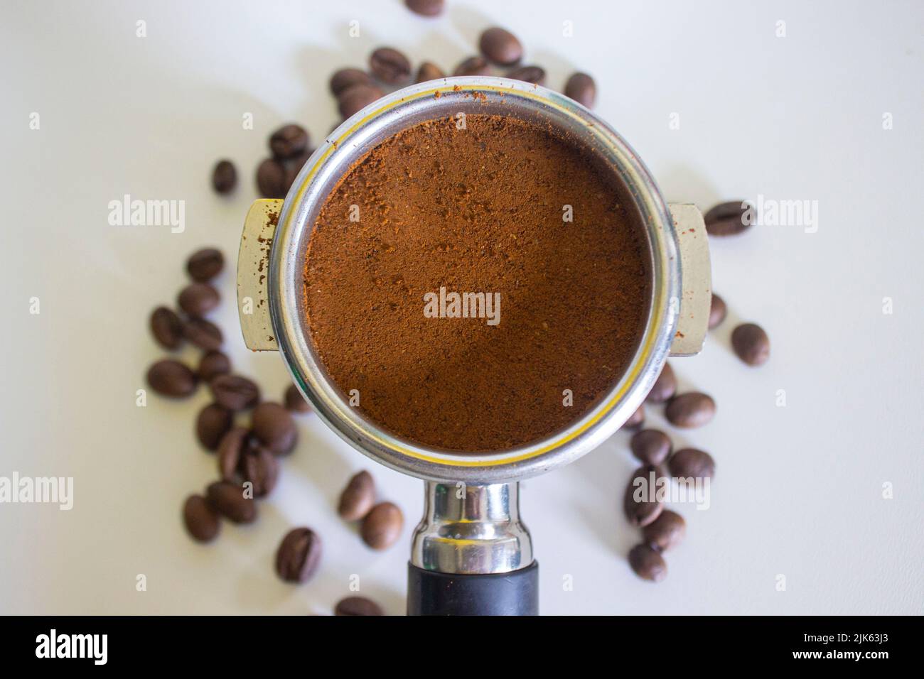 porta filter with ground coffee and coffee bean isolated from a white ...