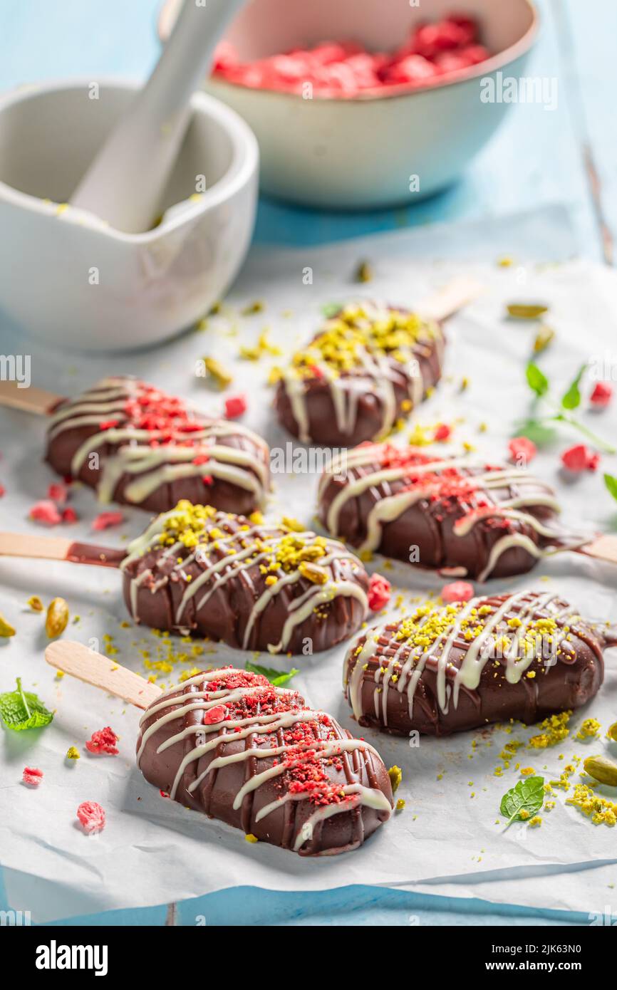 Sweet and chocolate popsicles with chocolate topping and pistachios ...