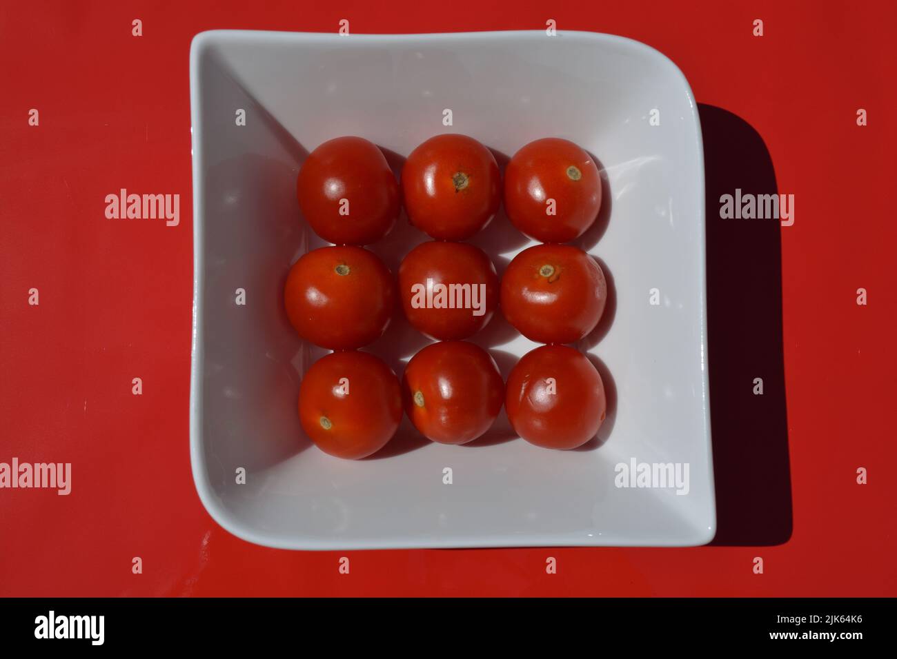 Fresh cherry tomatoes in a white square bowl Stock Photo - Alamy