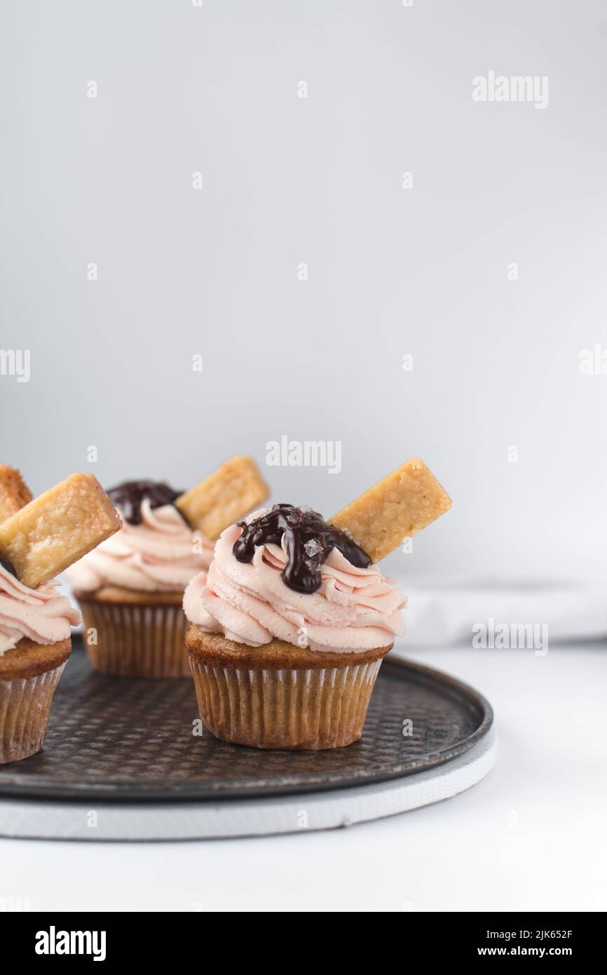 Single vanilla cupcake with a tall swirl of pink frosting, chocolate ...