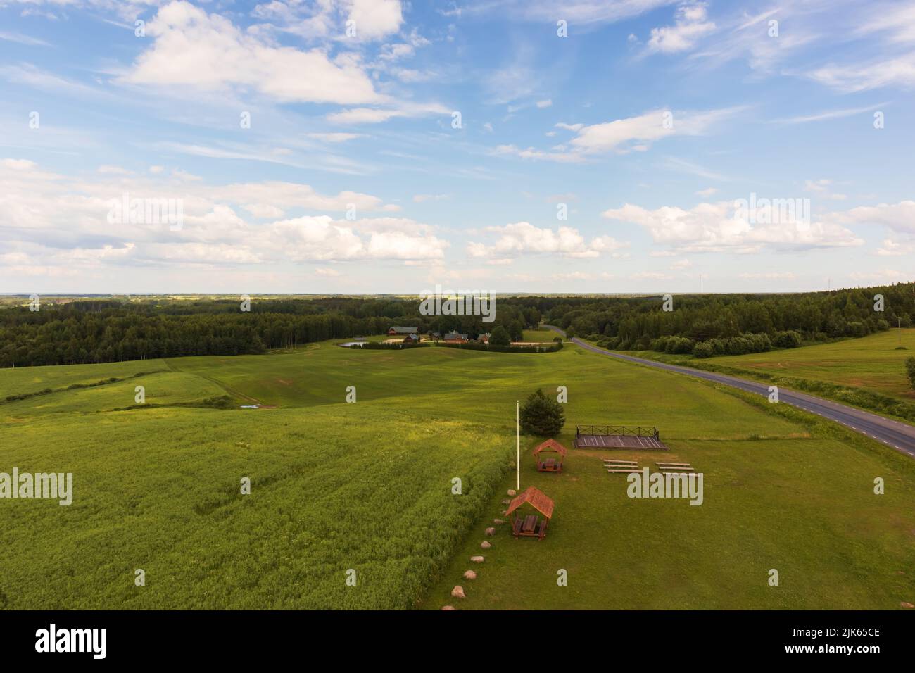 wide horizontal nature view with green grass, wooden houses, green ...