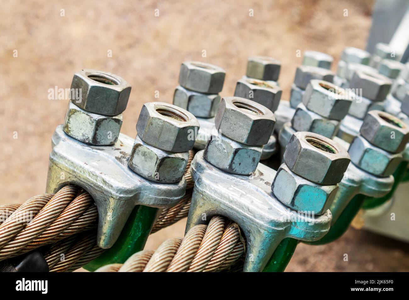 Metal screw bridge cable tie with brown sand background Stock Photo - Alamy