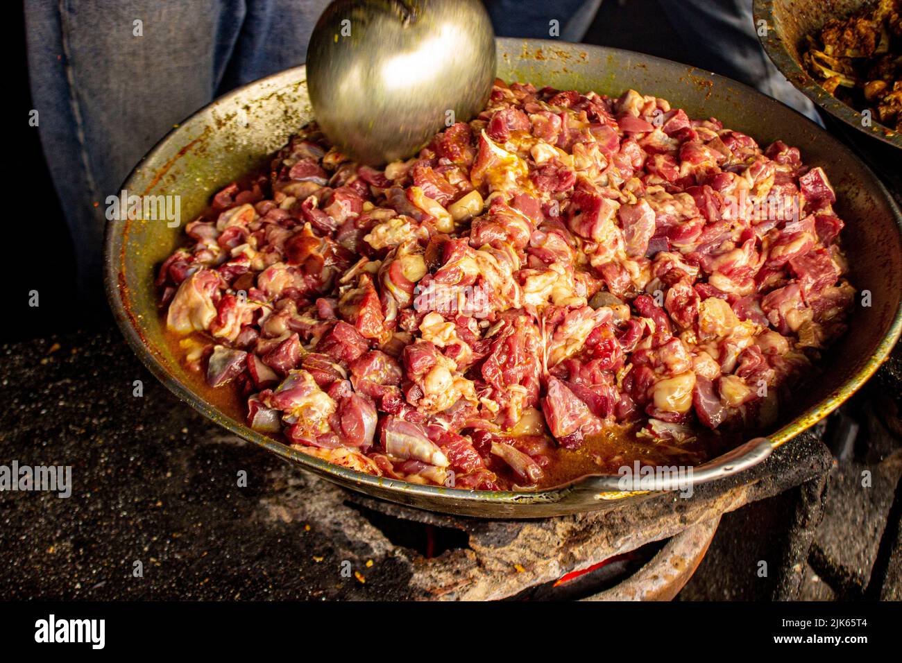 Traditional cooking raw meat with yellow curry or Tongseng in pan ...