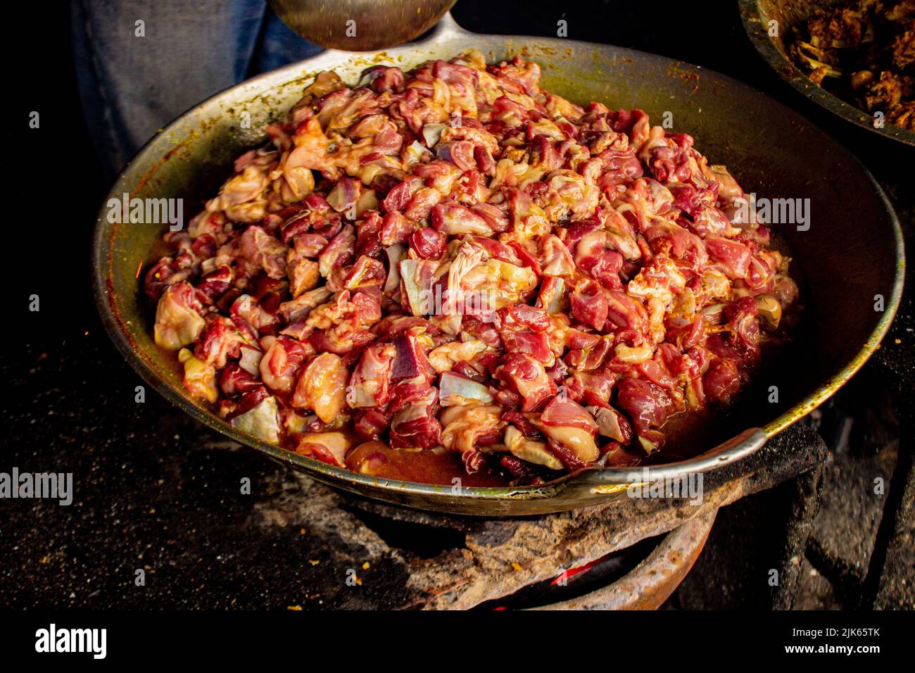 Traditional cooking raw meat with yellow curry or Tongseng in pan ...