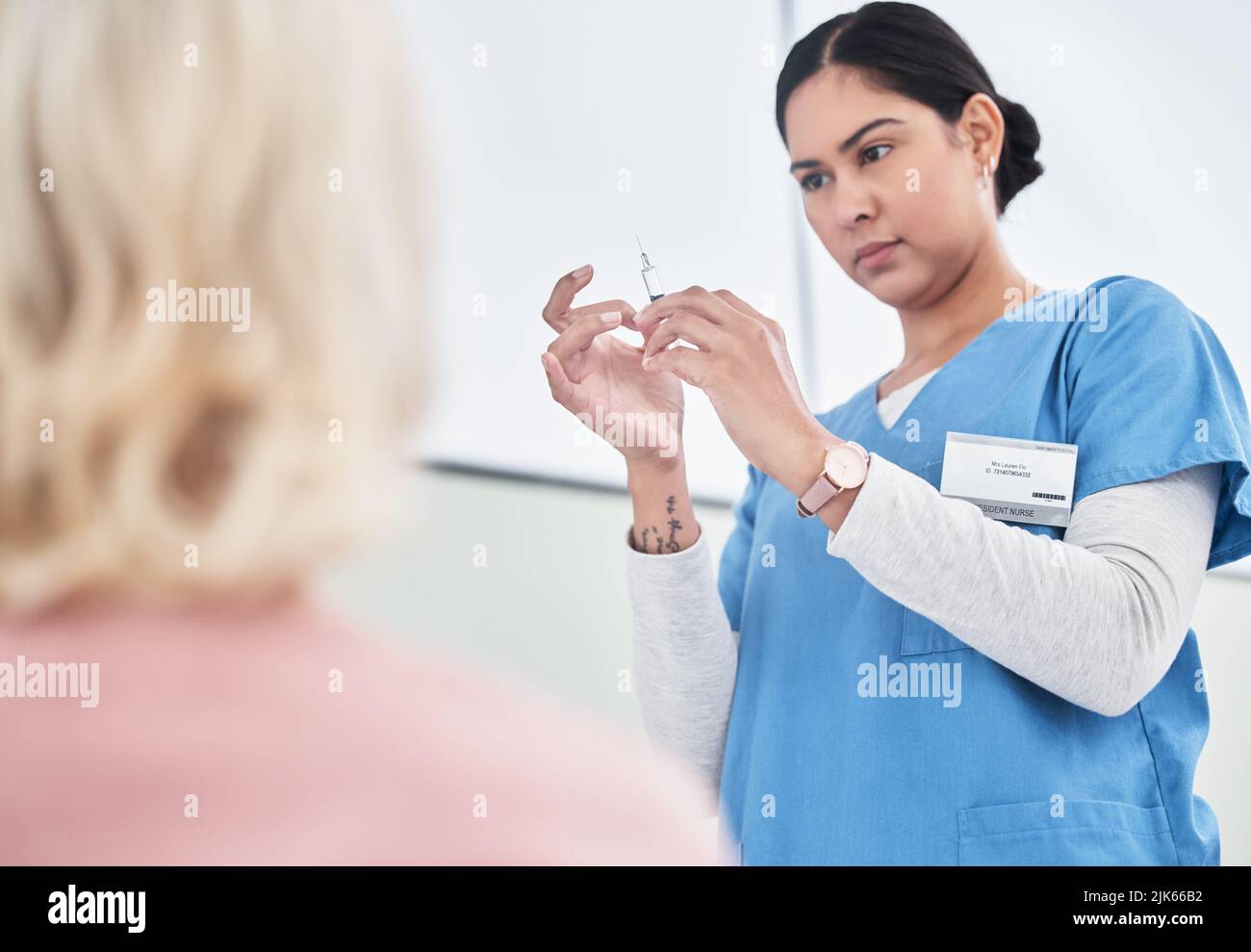 Making sure the dosage is just right. a female nurse getting ready to ...