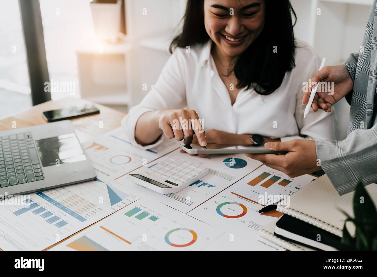 Business people discussing the charts and graphs in tablet about ...